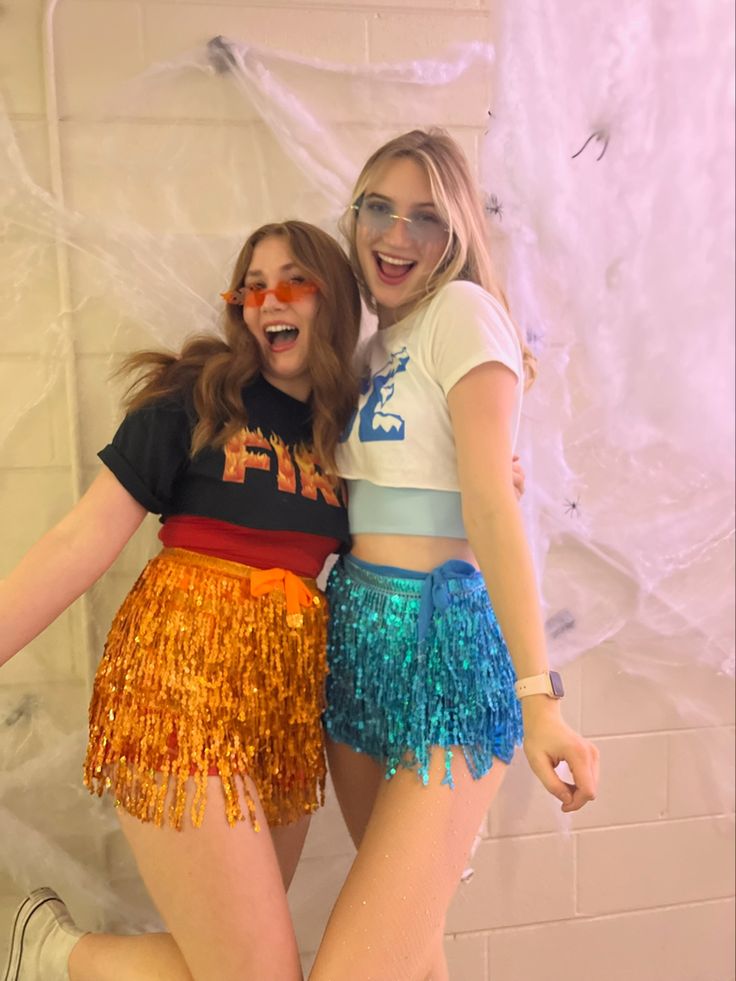 Two Girls In Colorful Skirts Pose For The Camera With Their Hands On