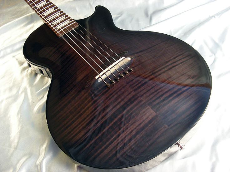 A Close Up Of A Guitar On A White Sheet