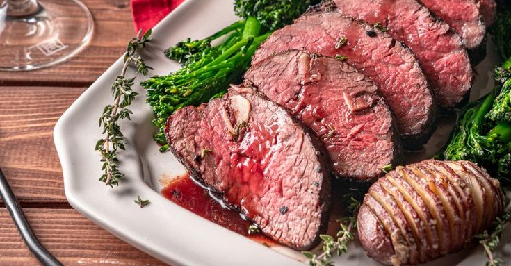 Steak And Broccoli On A White Plate With Red Wine In The Glass Next To It