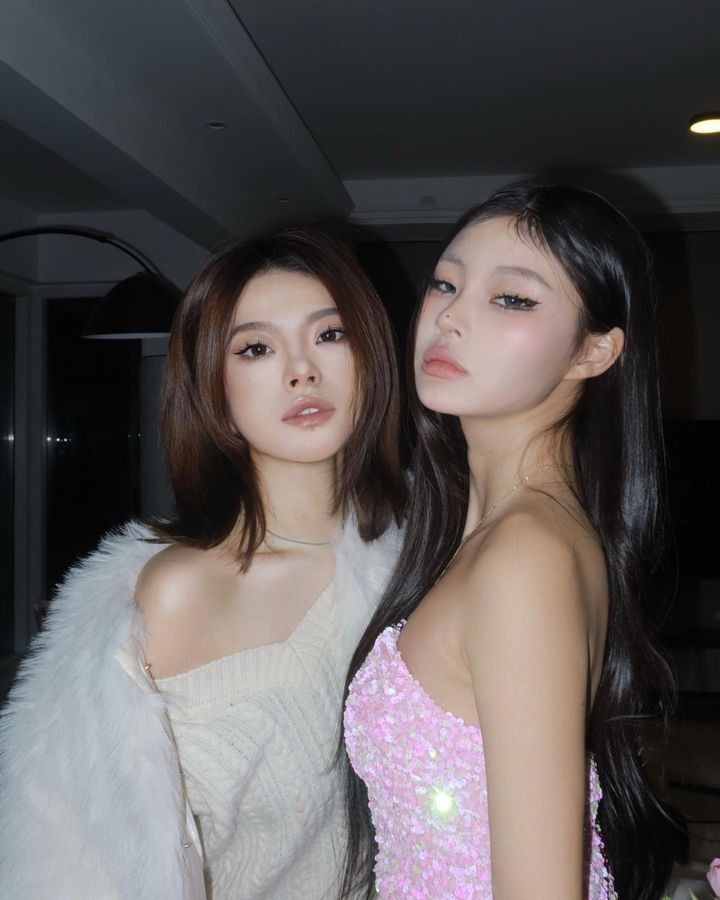 two women standing next to each other in front of a mirror two women standing next to each other in front of a mirror