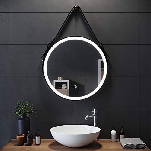 a bathroom with a round mirror above the sink and various items on the ... a bathroom with a round mirror above the sink and various items on the ...