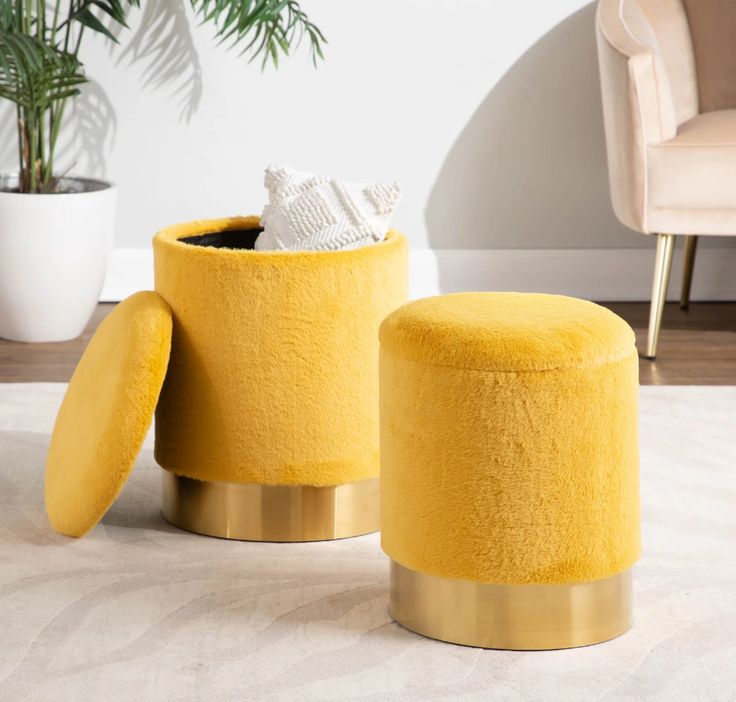 A Pair Of Yellow Stools Sitting On Top Of A White Rug Next To A Potted