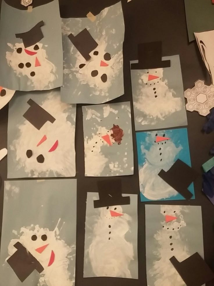 Snowmen Made Out Of Construction Paper Sitting On Top Of A Table