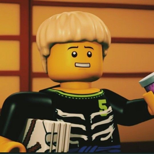 A Lego Man Holding A Cup And Wearing A Black Shirt With White Hair Is Standing In Front Of A Red