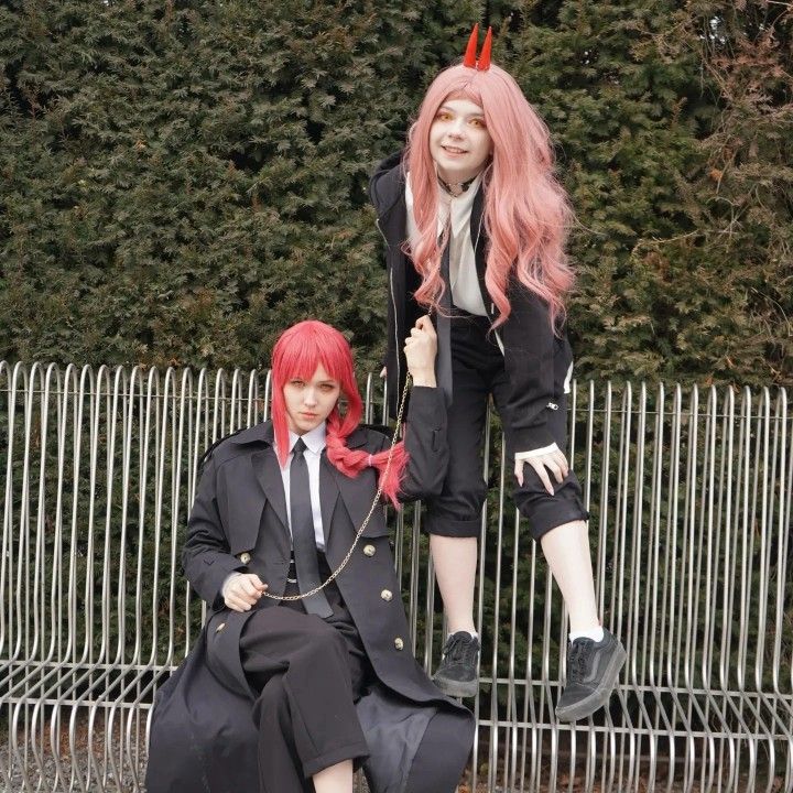 Two People Dressed In Black Sitting On A Bench