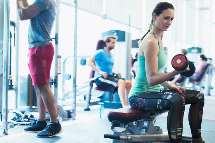 Woman Doing Dumbbell Biceps Curls At Gym By Caiaimages Bicep Curls