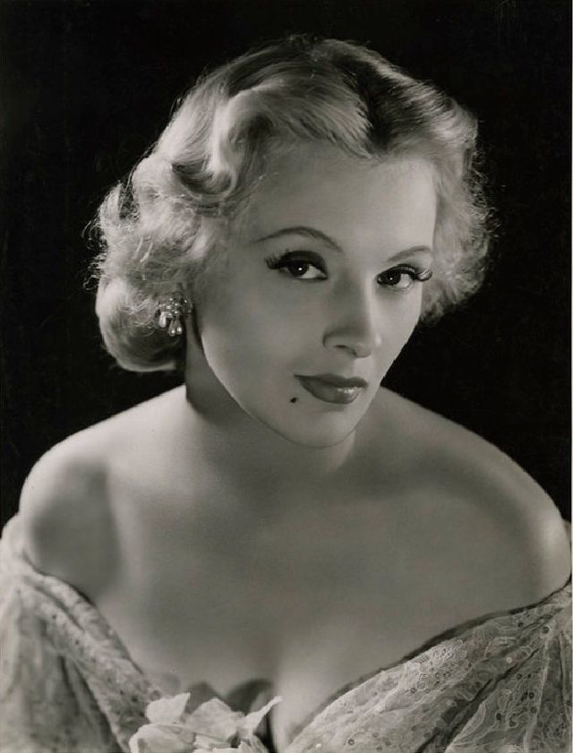 An Old Black And White Photo Of A Woman Wearing A Dress With Flowers On It