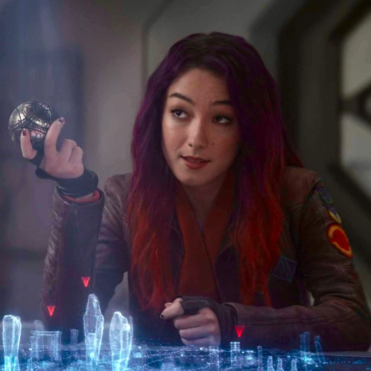 An Image Of A Woman With Red Hair Holding A Sci Fi Object In Her Hand
