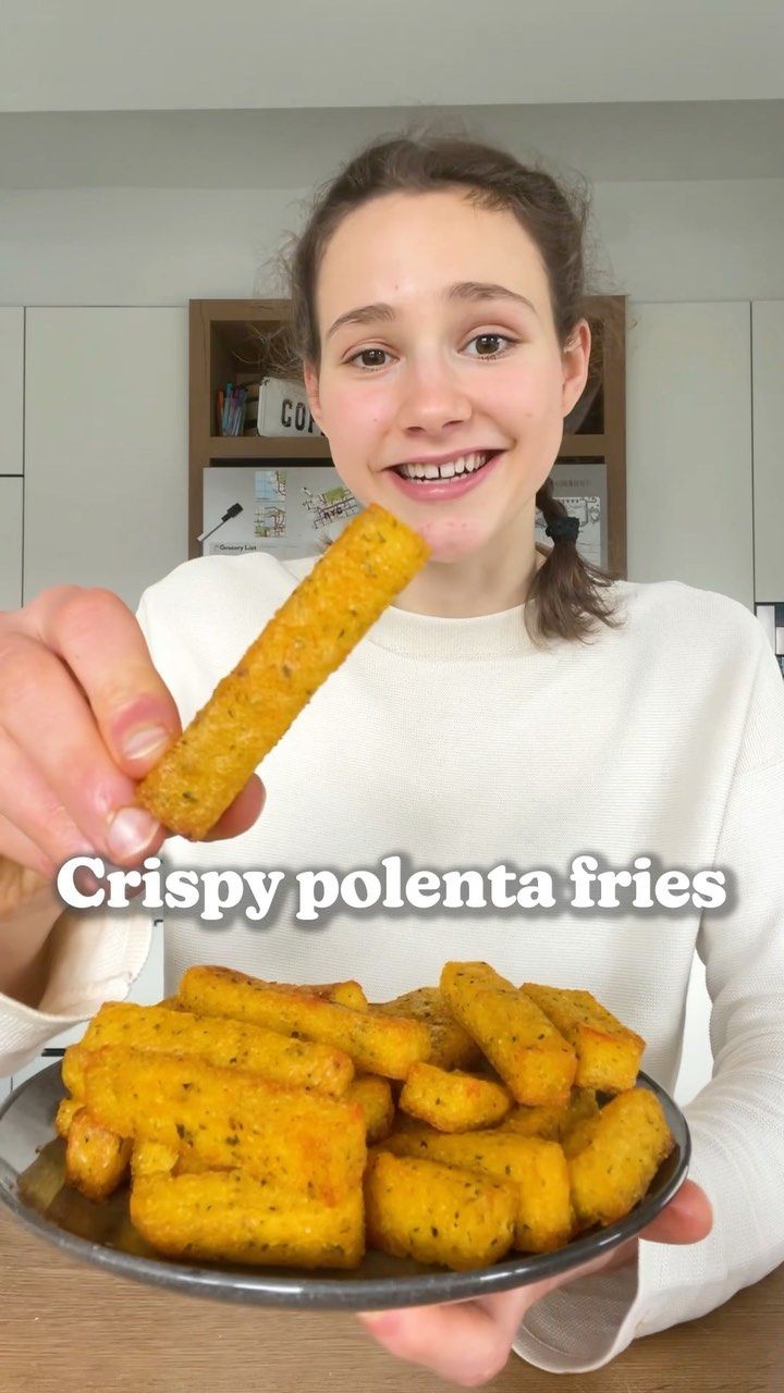 A Girl Is Holding A Plate Full Of Crispy Polenta Fries With The Caption Crispy Polenta Fries