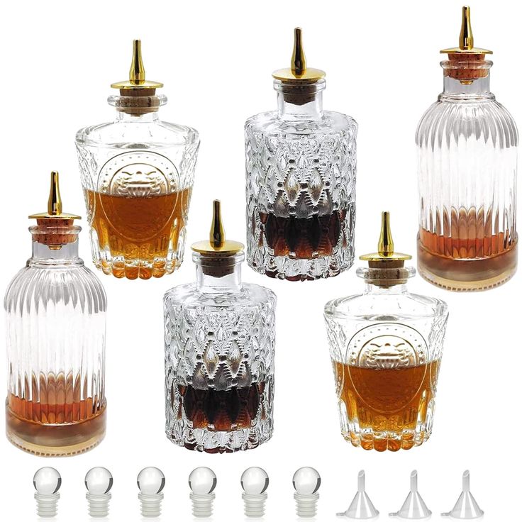 Six Clear Glass Bottles With Gold Caps And Spoons
