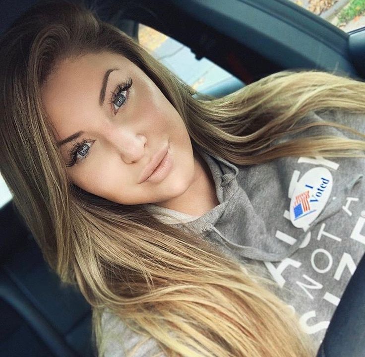 A Woman Sitting In The Back Seat Of A Car With Long Blonde Hair And