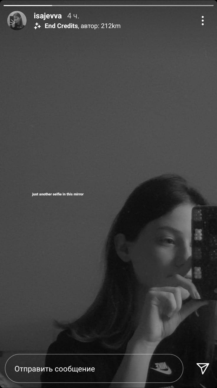 A Woman Taking A Selfie In Front Of A Mirror With Her Cell Phone Up To Her Face