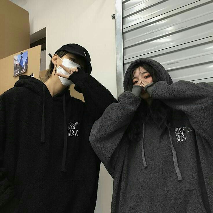 Two People Standing Next To Each Other With Masks On