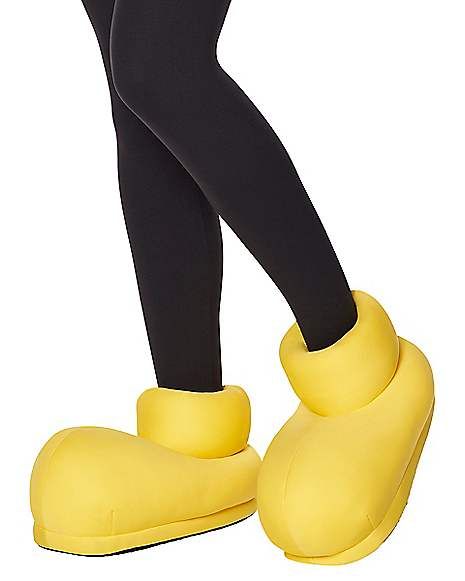 The Legs And Feet Of A Person Wearing Yellow Slippers With Black Leggings