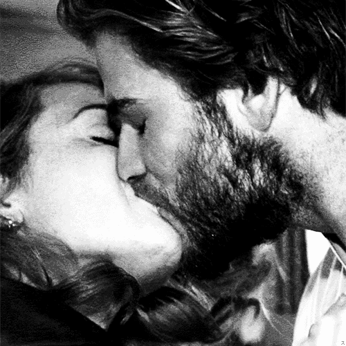 A Man And Woman Are Kissing Each Other