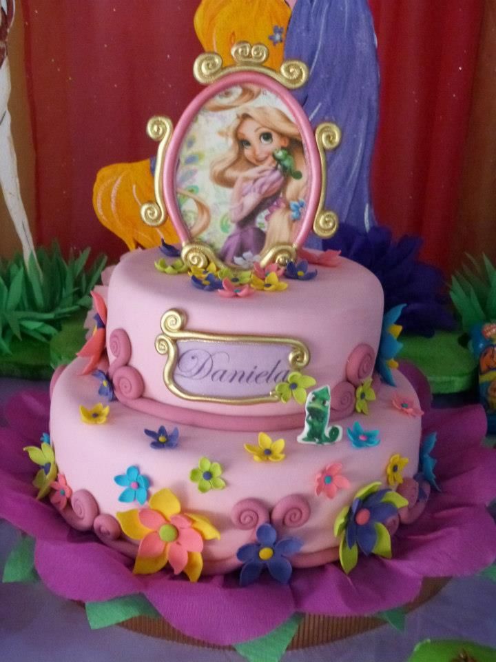 There Is A Pink Cake Decorated With Princesses And Flowers