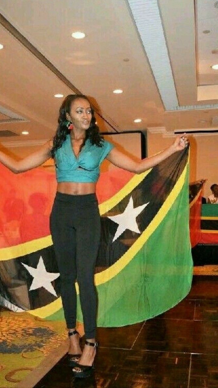 A Woman Holding A Flag In Her Hand And Posing For The Camera While