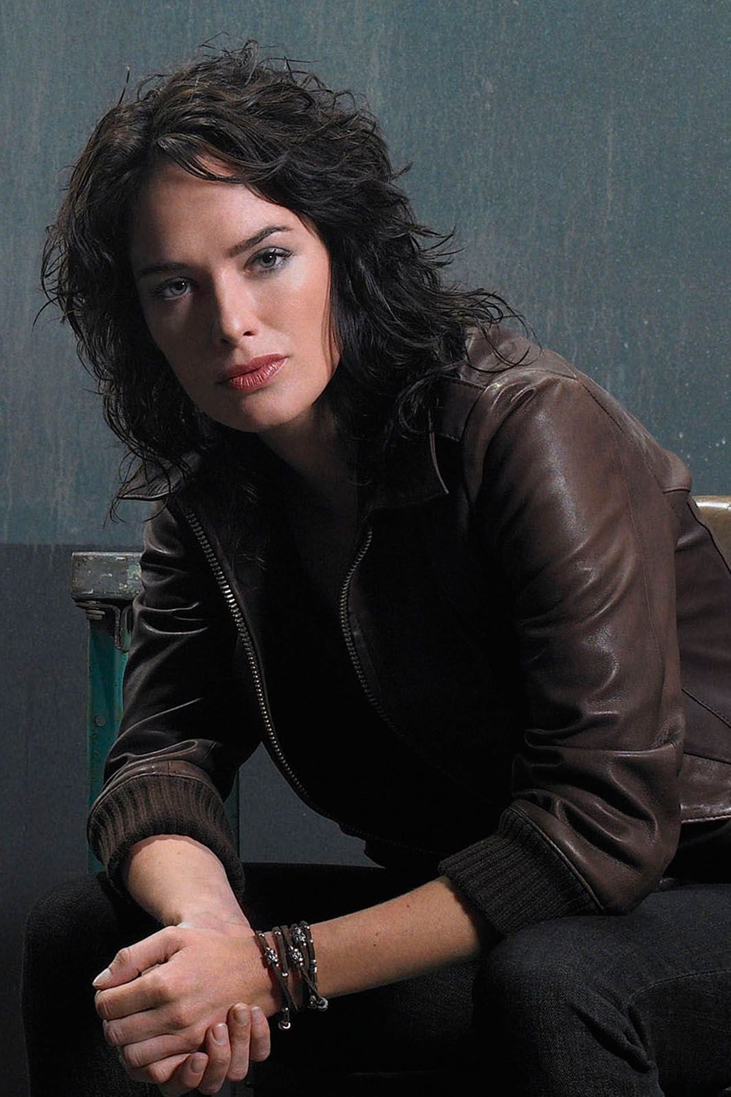 A Woman Sitting In A Chair With Her Hand On Her Knees Looking At The Camera