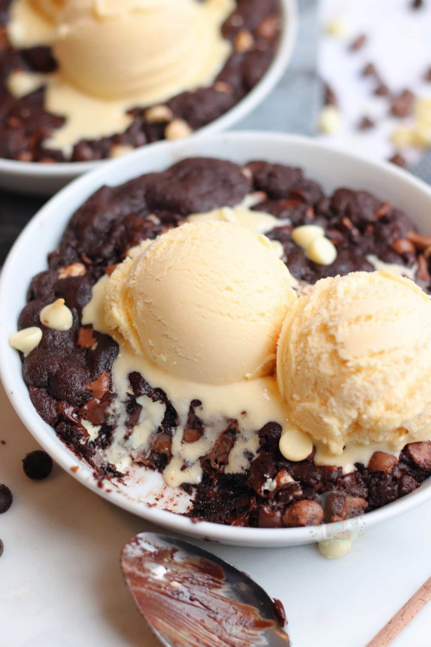 Two Bowls Filled With Ice Cream And Chocolate Cake Dessert On Top Of A