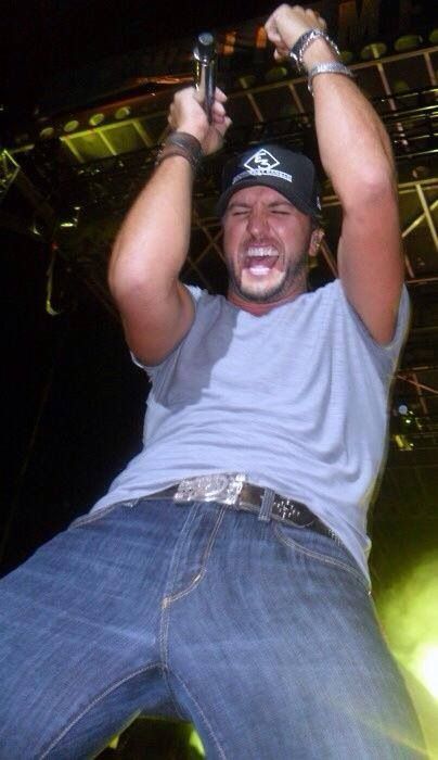 A Man In Jeans And A Baseball Cap Holding A Microphone