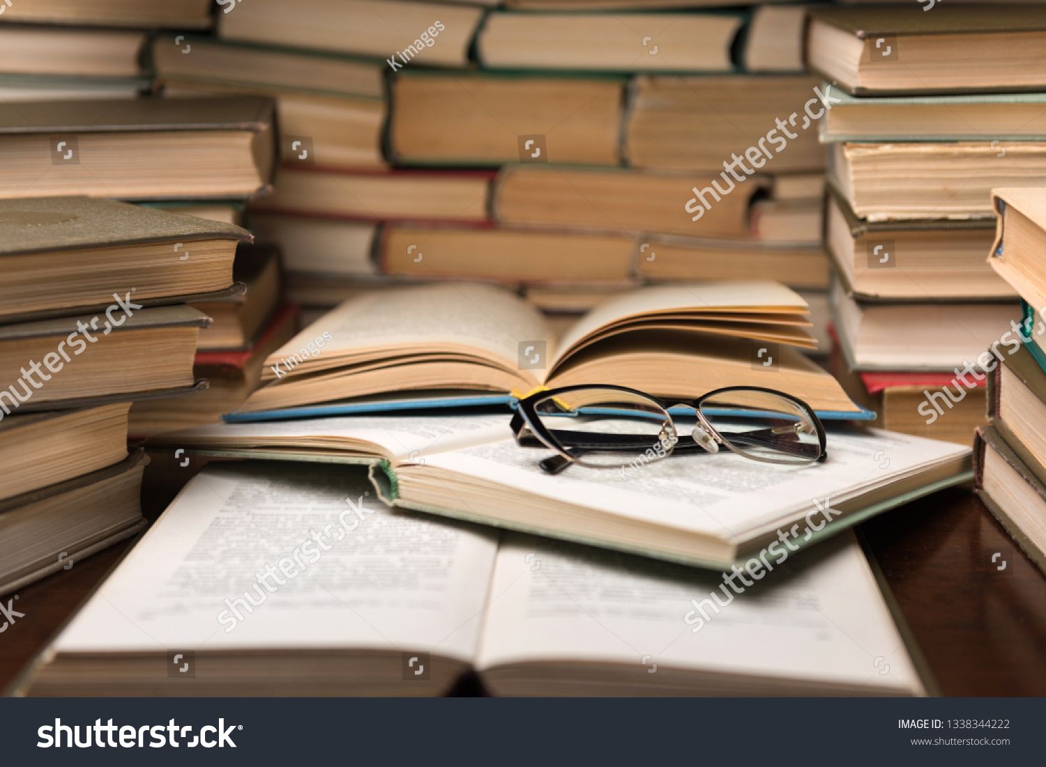 Open Book And Glasses On Wood Desk In The Library Room With Blurred
